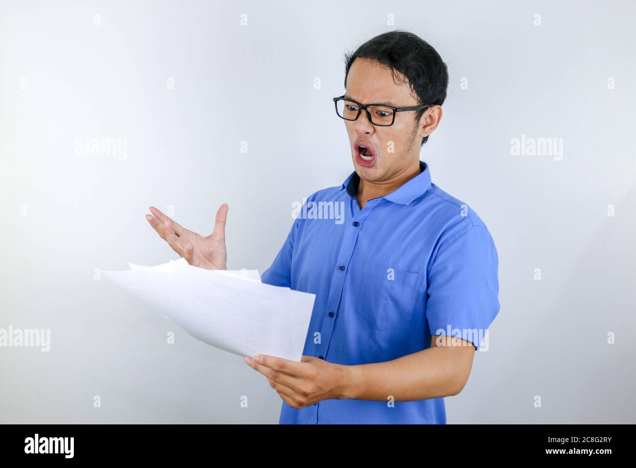 Young Asian man is shocked and surprised with the white mail message or ...