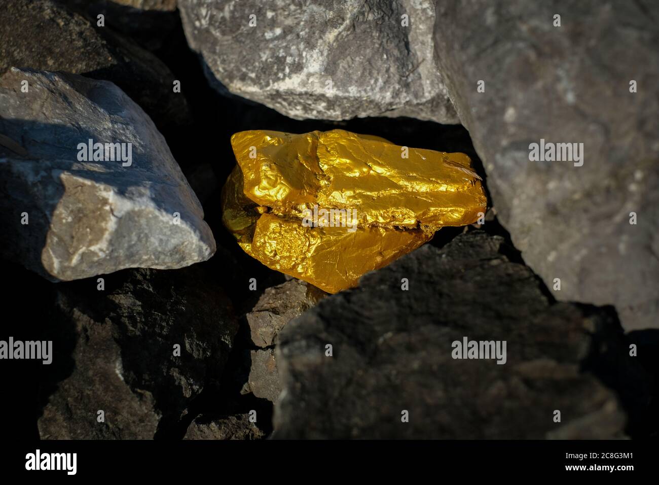 Gold nugget and grey granite stone background Stock Photo - Alamy