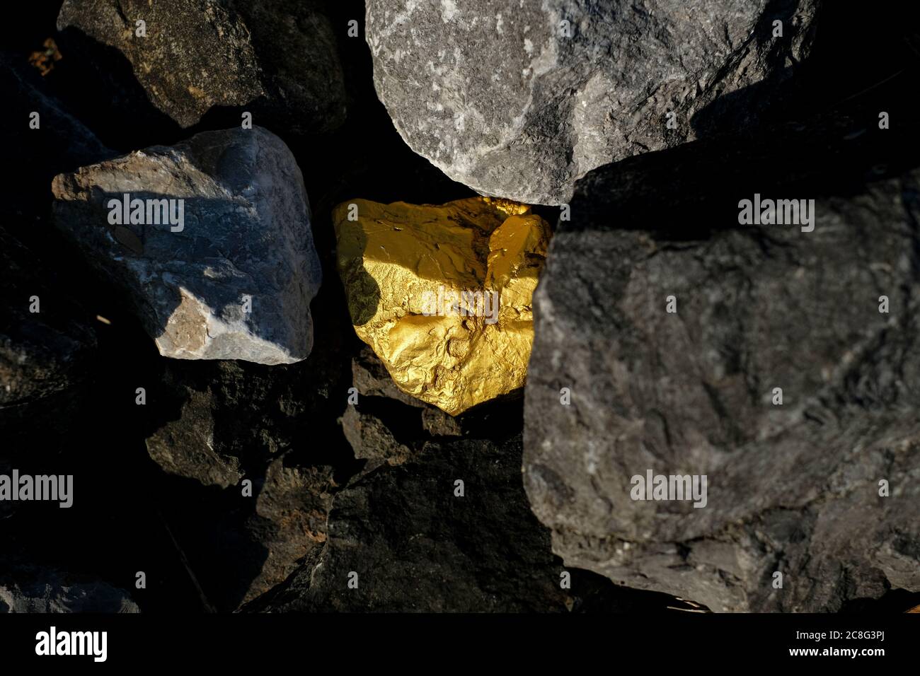 Gold nugget and grey granite stone background Stock Photo - Alamy