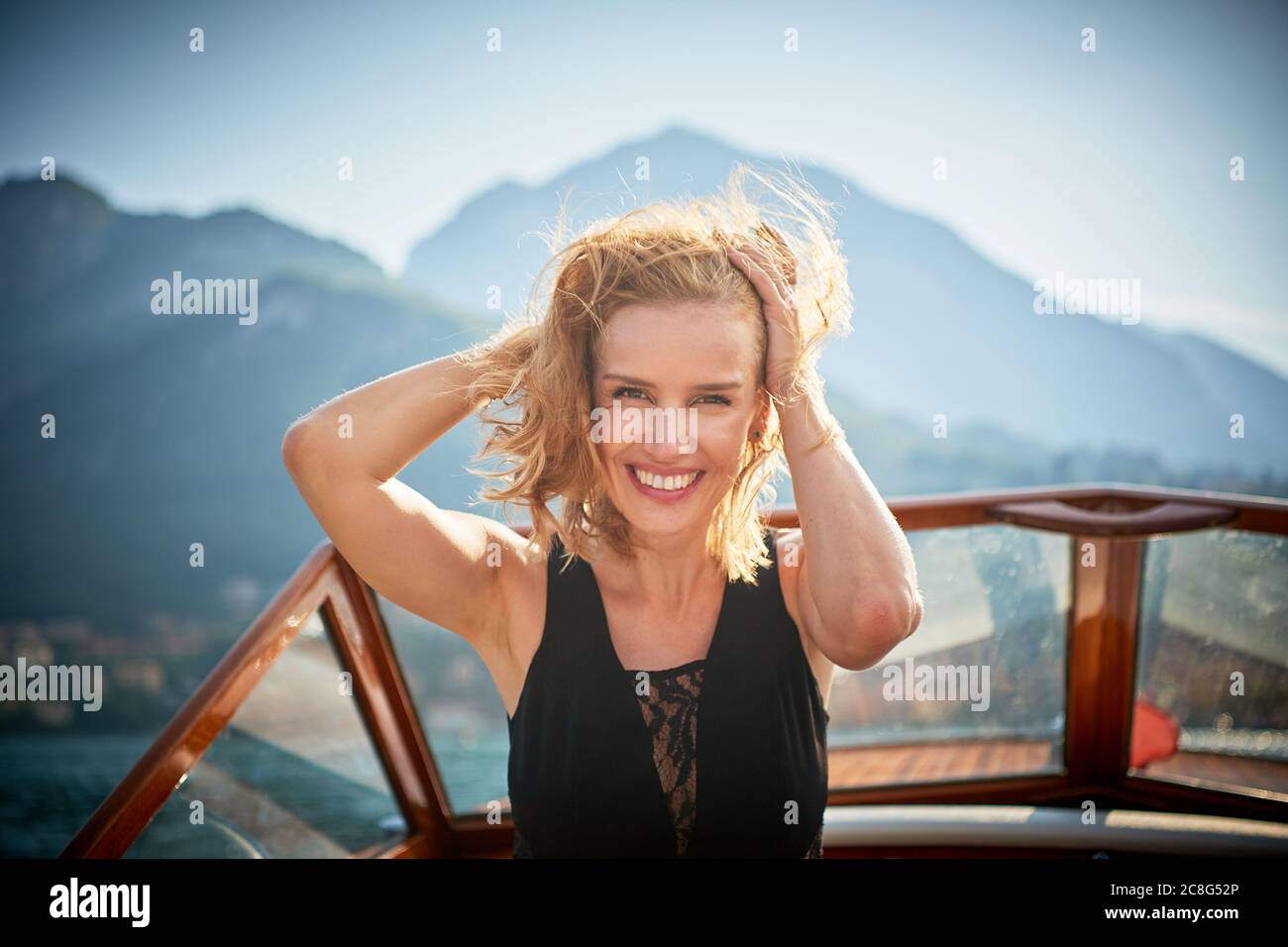 Beautiful model aboard a vintage wooden speedboat on Lake Como, Italy ...