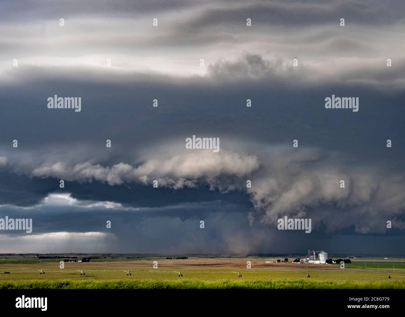 Dark and light wall clouds spin below a tornado super-cell kicking up ...