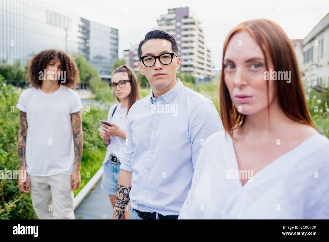 Mixed race group of friends hanging out together in town Stock Photo ...