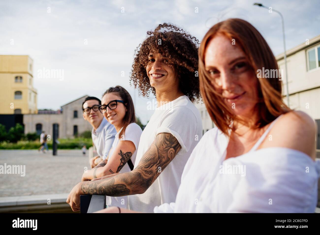 Mixed race group of friends hanging out together in town Stock Photo ...