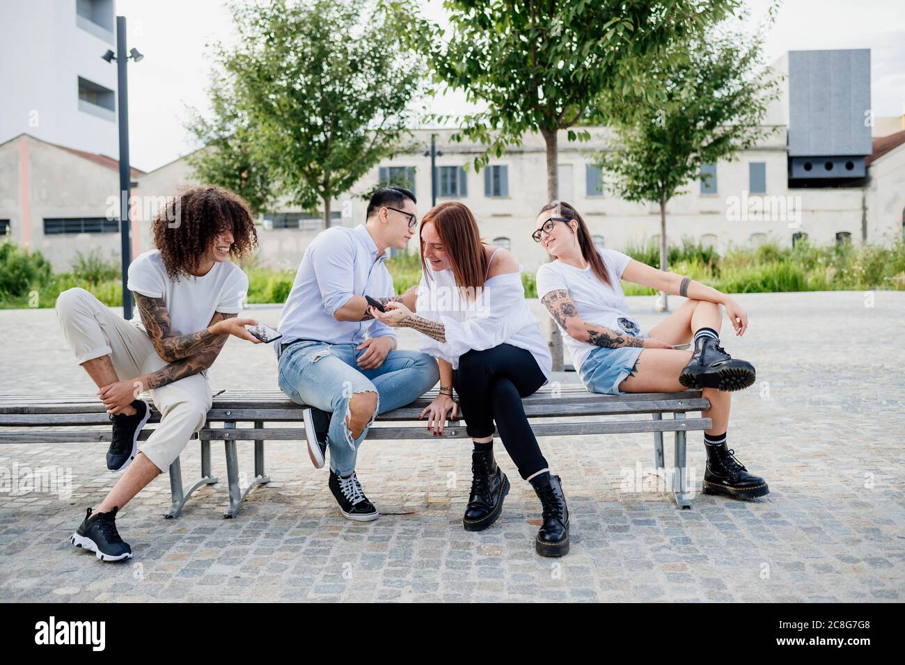 Mixed race group of friends hanging out together in town Stock Photo ...