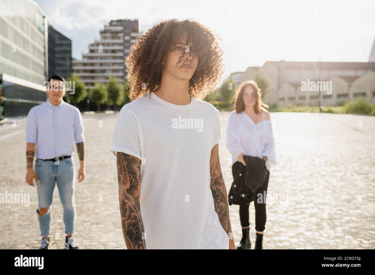Mixed race group of friends hanging out together in town Stock Photo ...