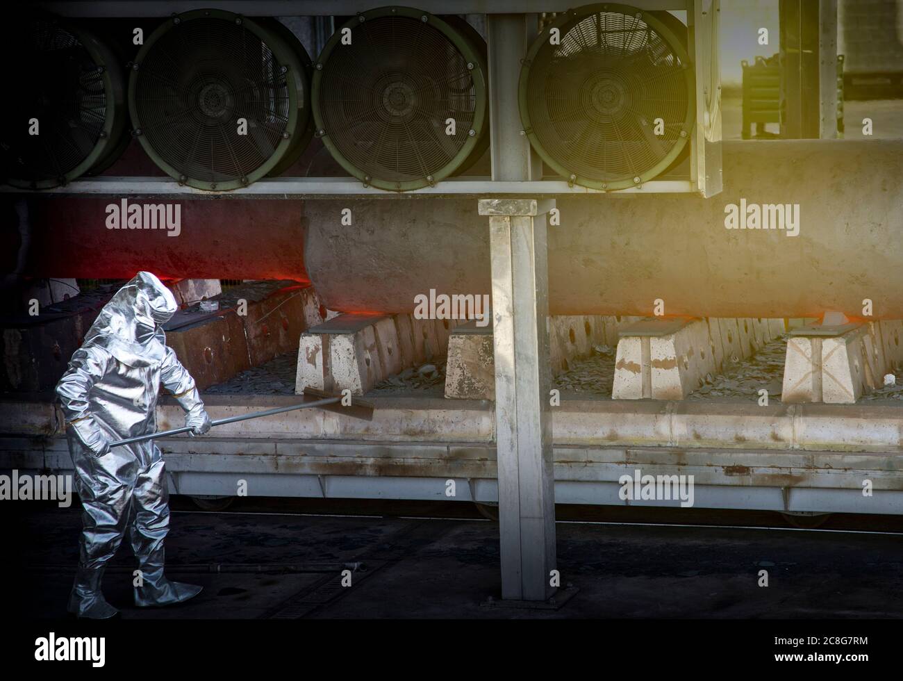 Man wearing silver heat-protective suit working in a steel factory ...