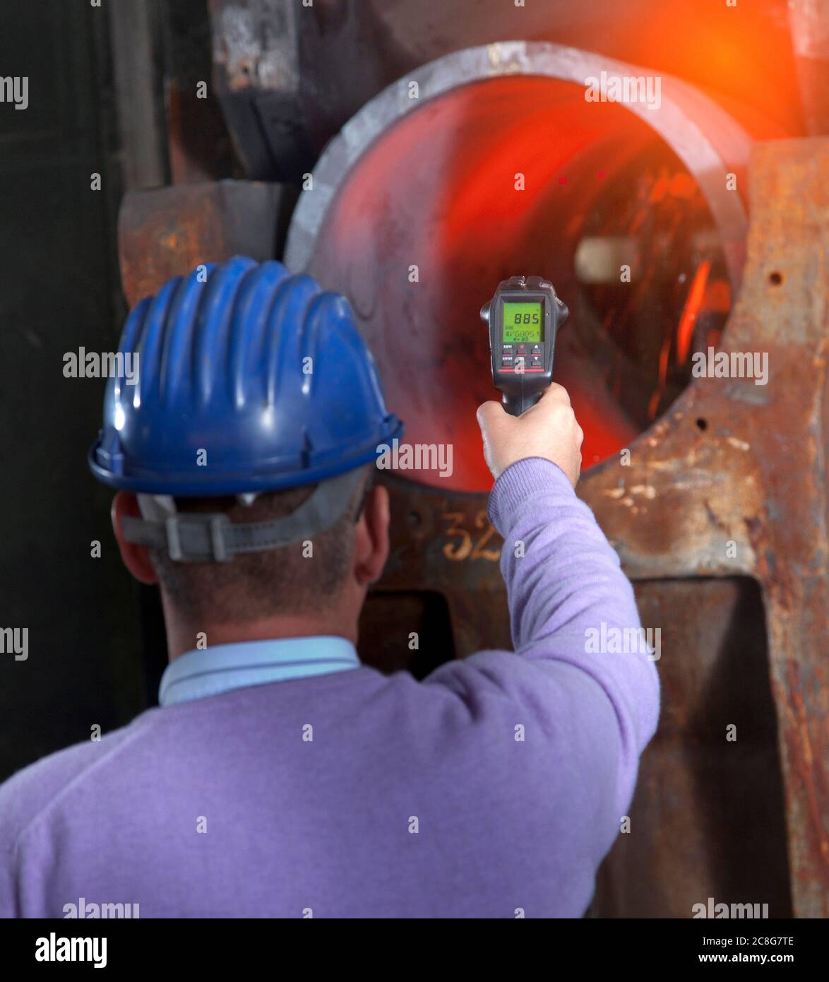 Man working in a steel factory, inspecting steel tube Stock Photo - Alamy