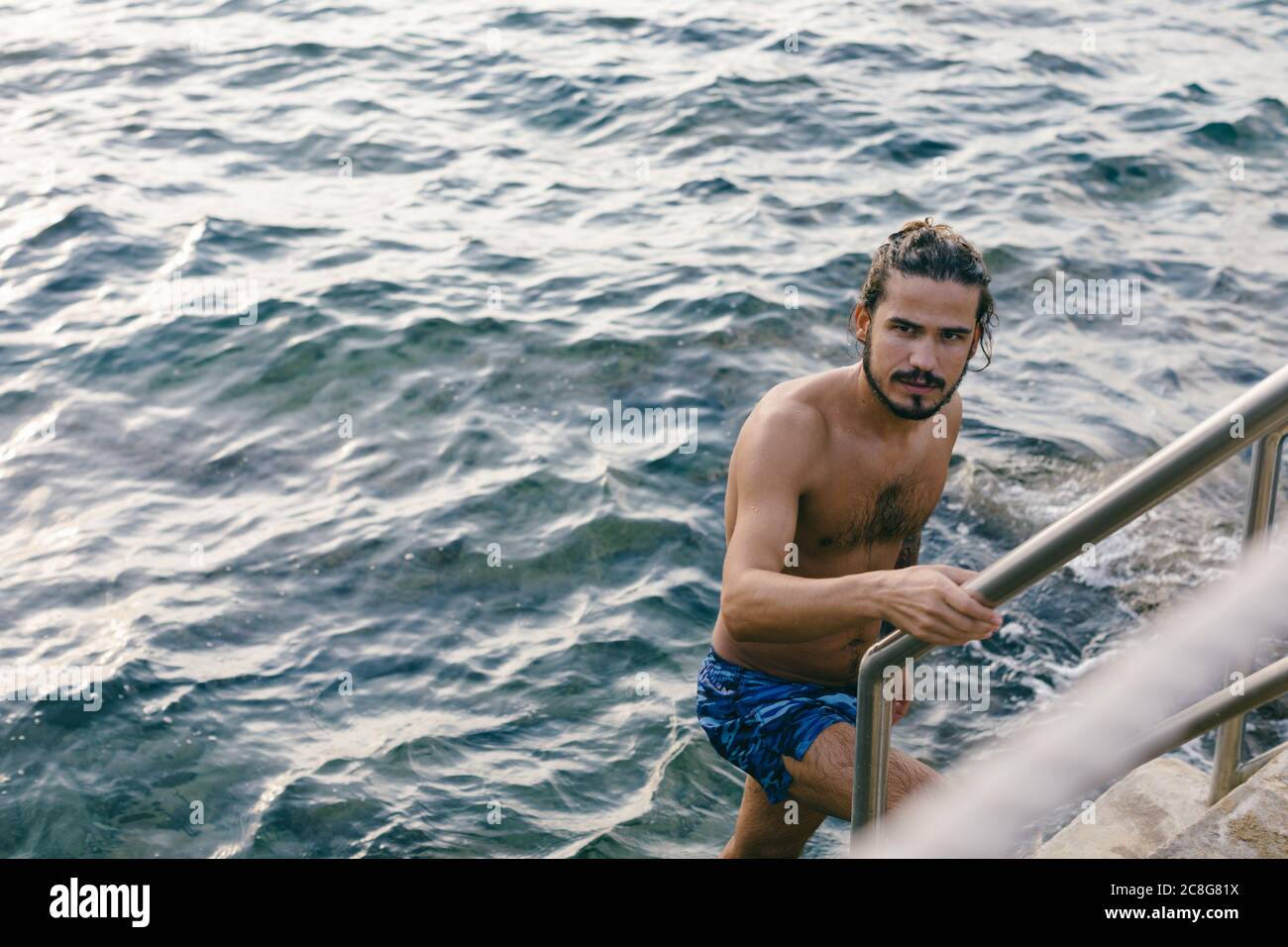 Man going up steps from sea Stock Photo - Alamy
