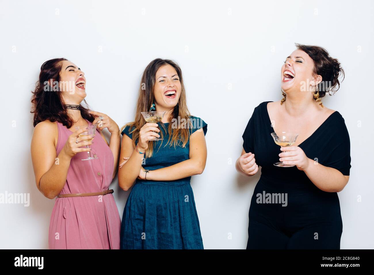 Friends laughing and celebrating with drinks Stock Photo - Alamy