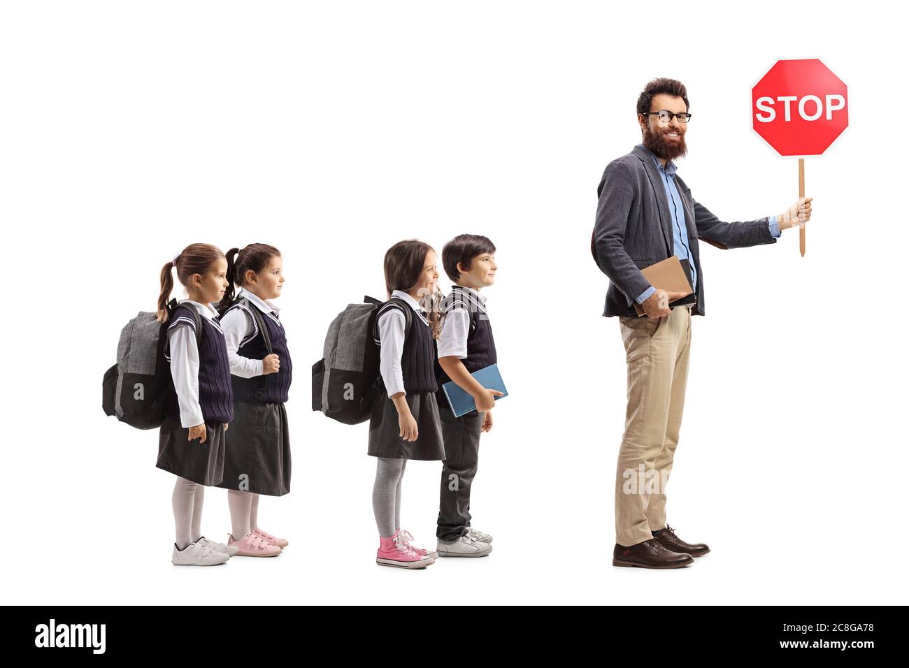 Male teacher carrying a stop sign with a group of schoolchildren in ...