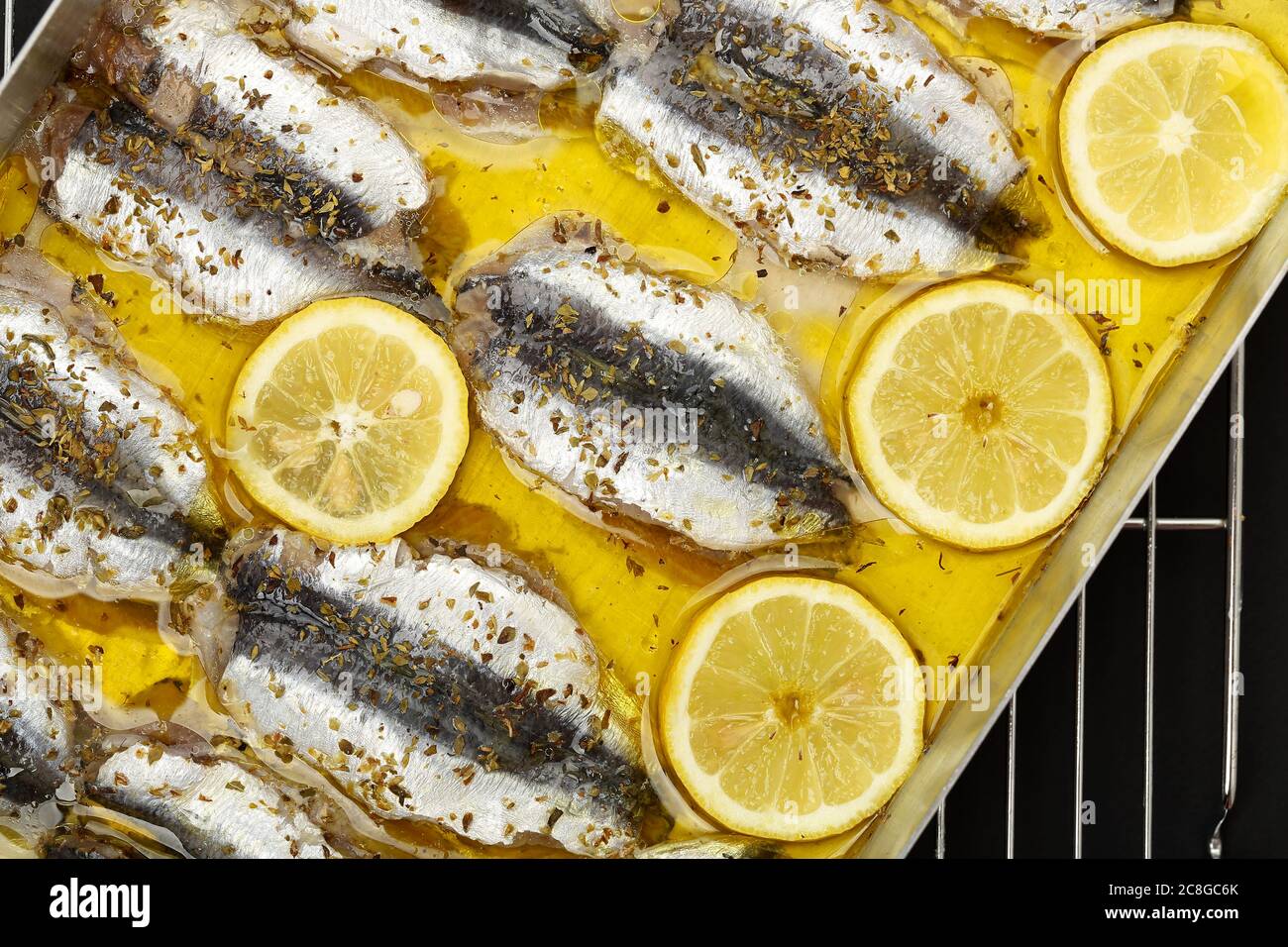 uncooked sardines fillet with lemon slices in olive oil Stock Photo - Alamy