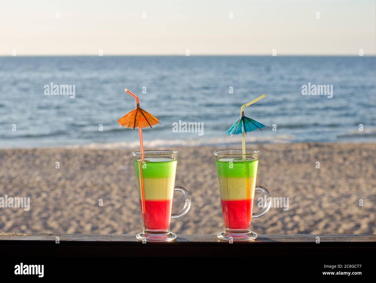 Tricolor cocktail on the bar counter with a sandy beach overlooking the ...