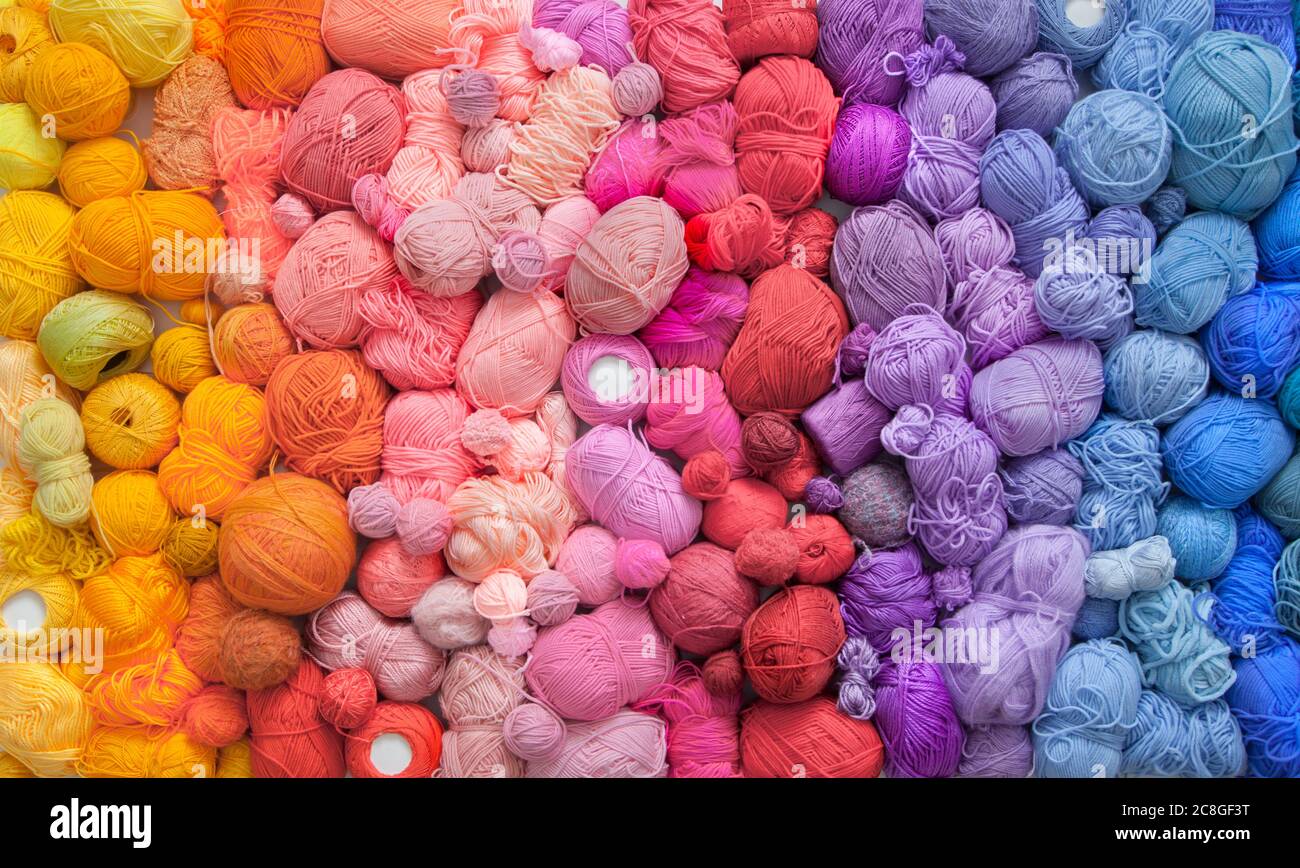 Colored balls and skiens of yarn for knitting. Top view. Rainbow colors ...