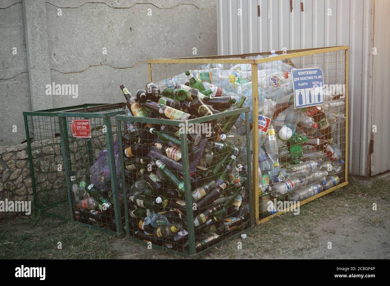 Glass and plastic bottles in garbage containers. Sorting and recycling garbage concept. August ...