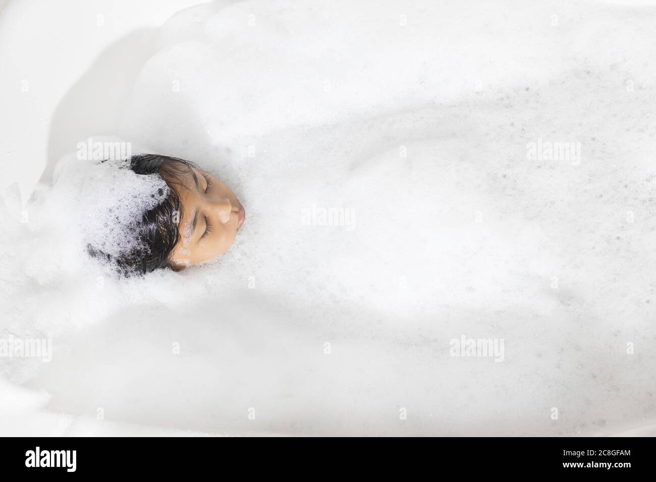 An Asian girl is happily soaking in a bubble bath Stock Photo - Alamy