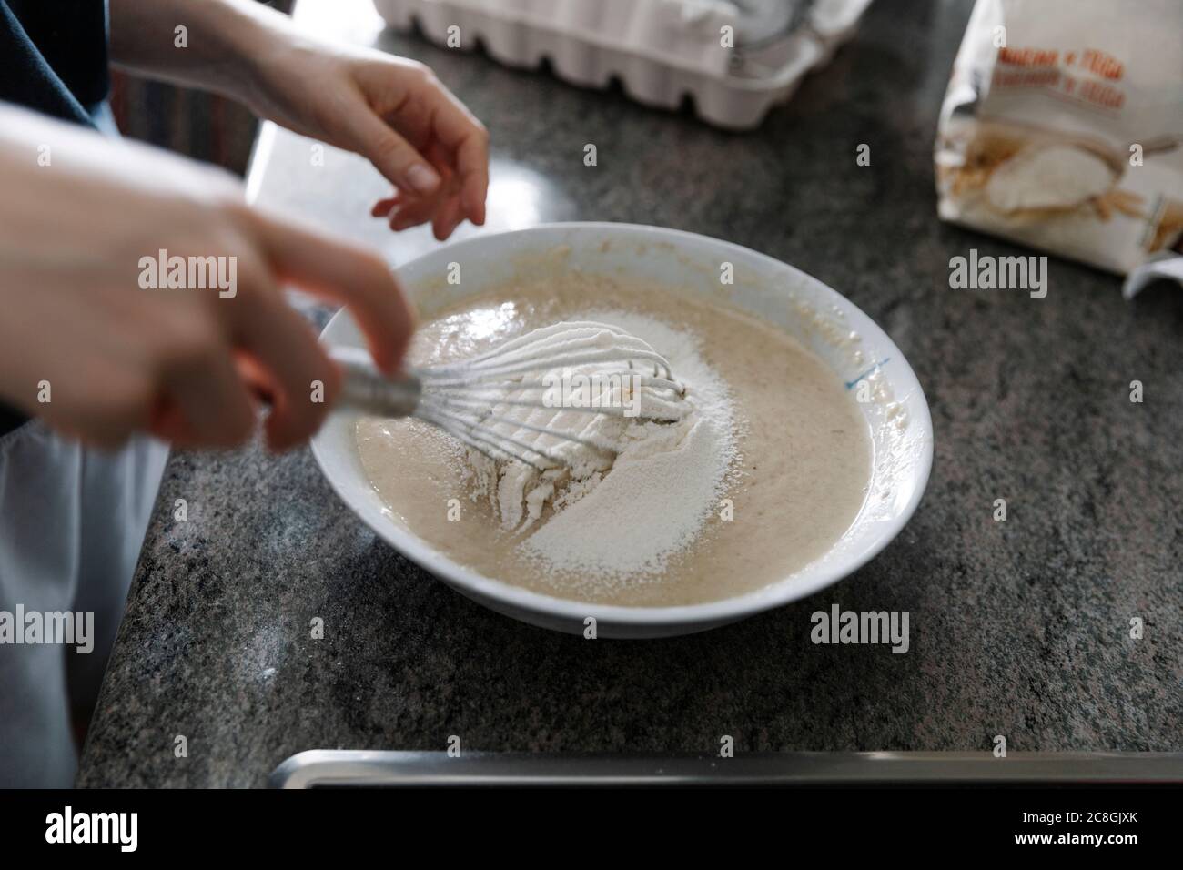 Anonymous person mixing flour into batter while cooking pastry at home ...