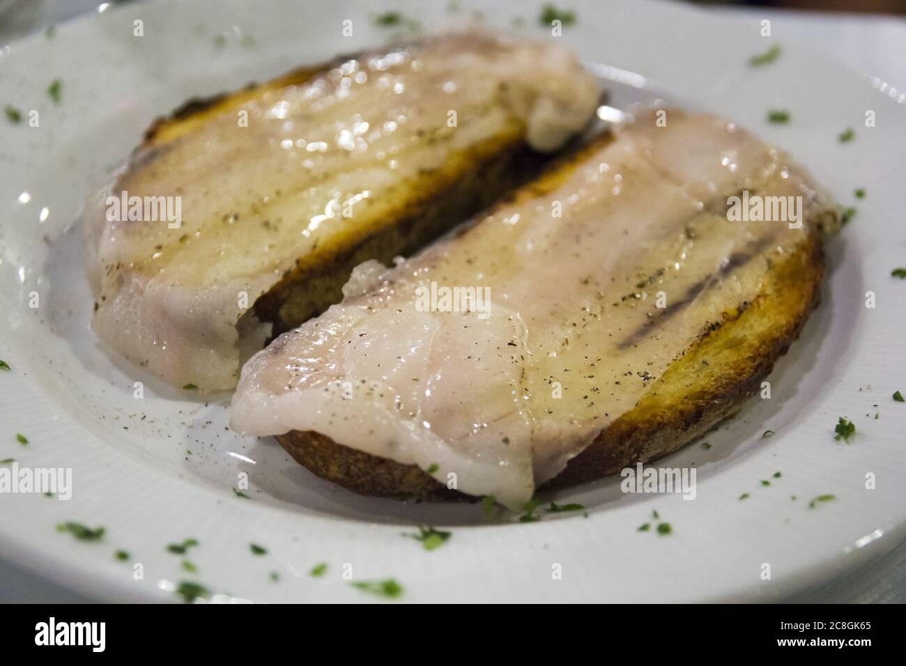 Italian bread (toasted bread) with pork lard and pepper. Traditional ...