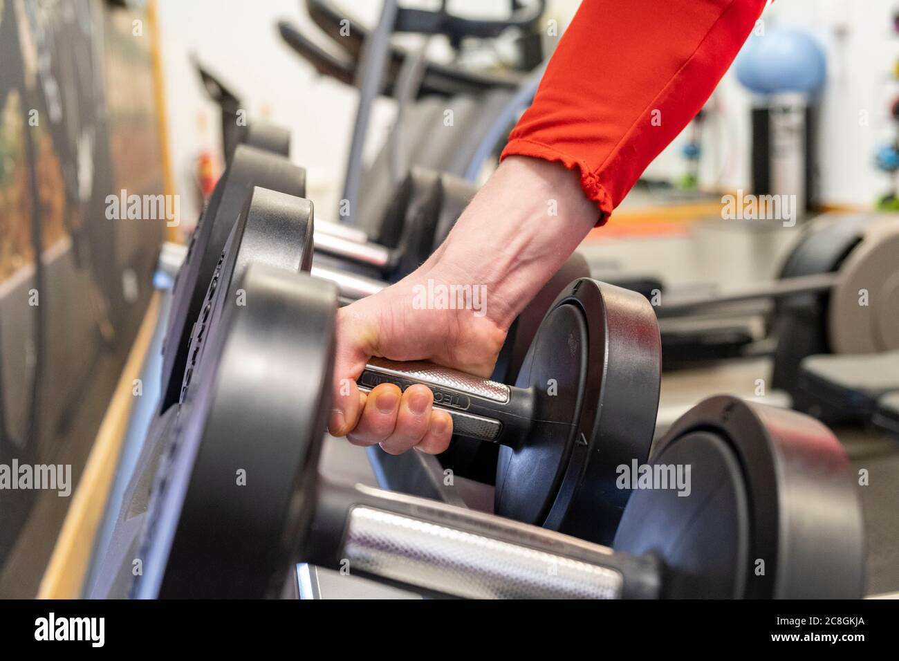 male lifting weights off of rack Stock Photo - Alamy