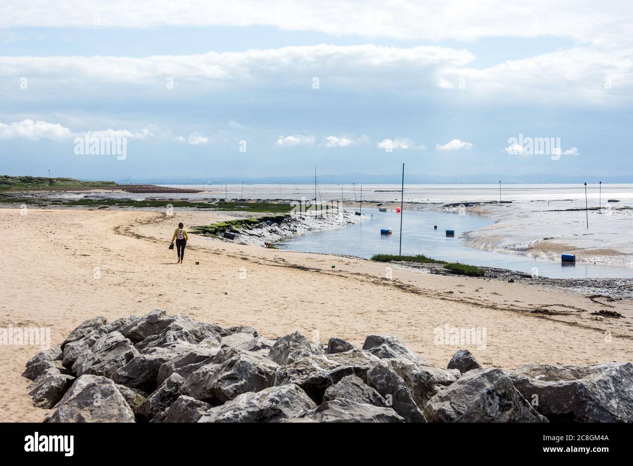 A woman walks on the beach at Hightown, Merseyside, UK Stock Photo - Alamy