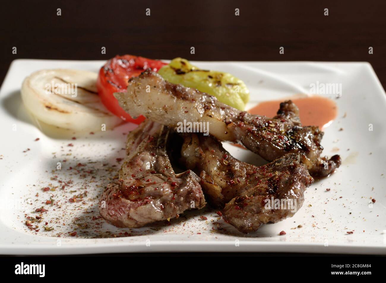 Delicious barbecue beef ribs close up with grilled vegetables on plate ...