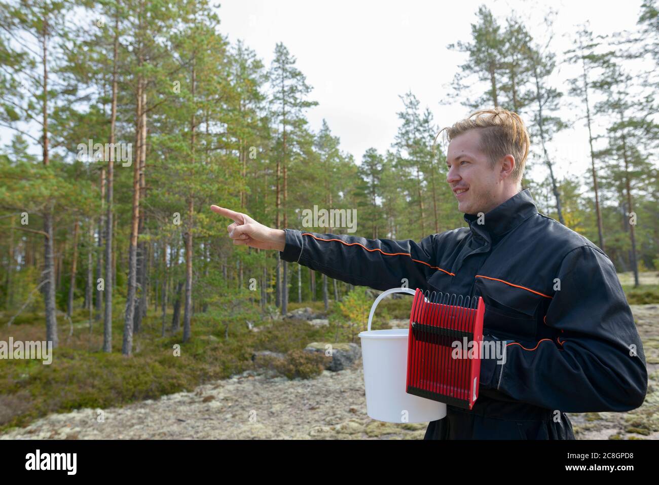 Portrait of happy young handsome man pointing finger while holding ...