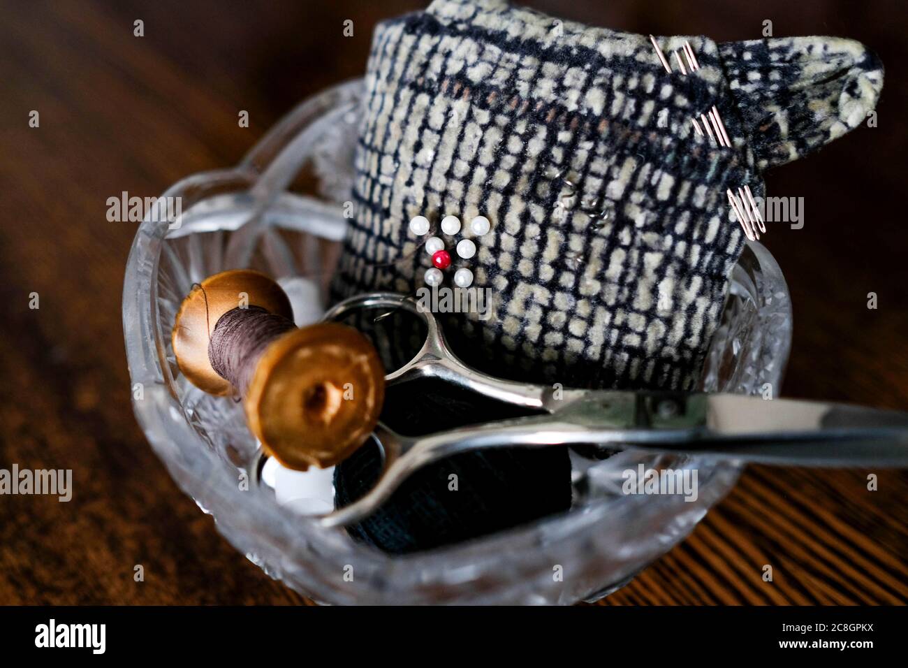 Tools for darning clothes. Scissors, spool of thread and pins in a ...