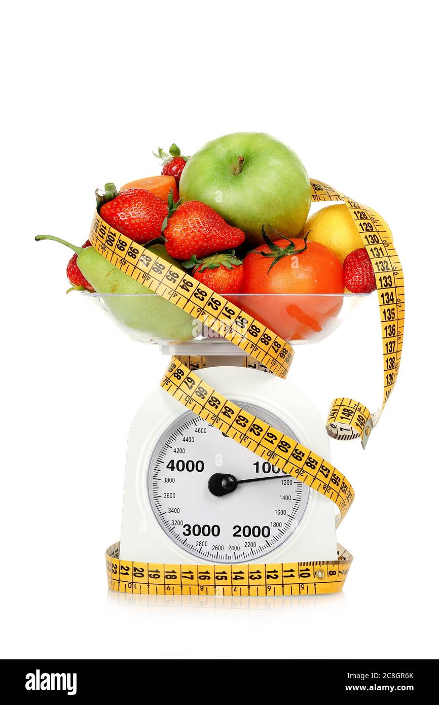 measuring tape around scales with fruits and vegetables, dieting ...