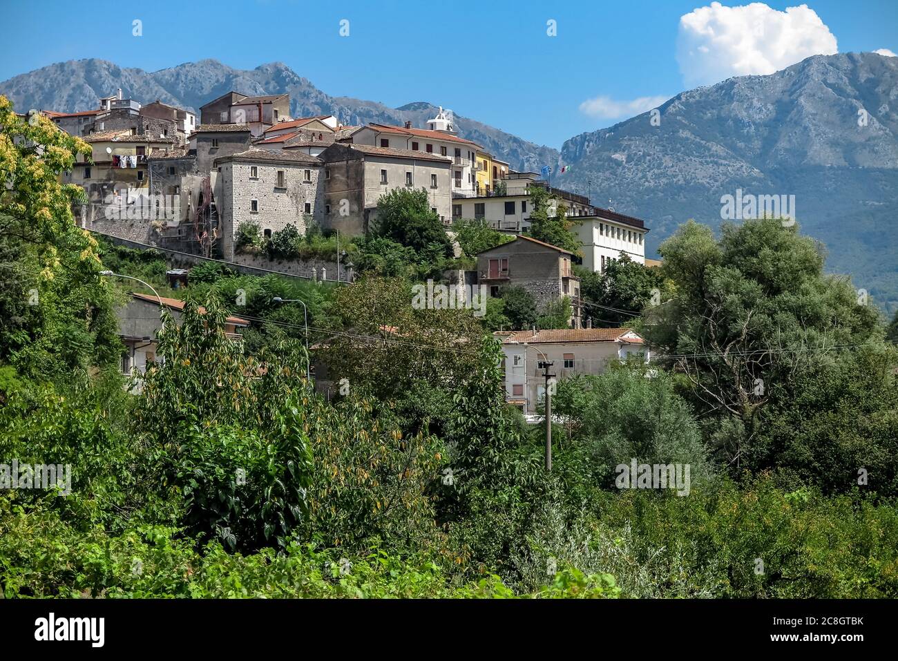 Small medieval Italian town on top of a hill, with high mountains in ...