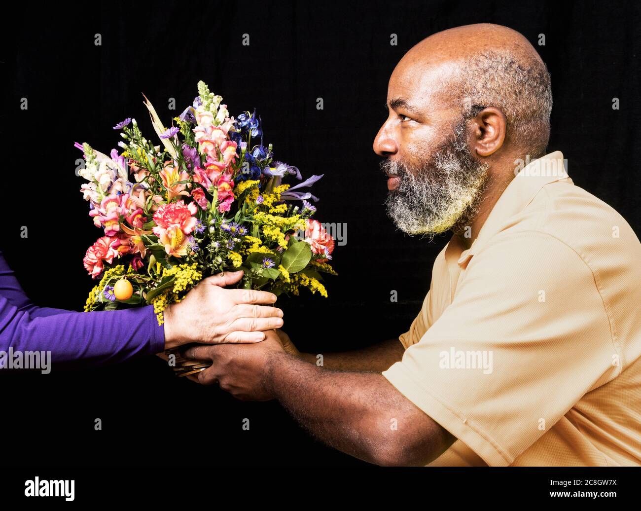 Colorful flower bouquet given to a male African American male on black ...