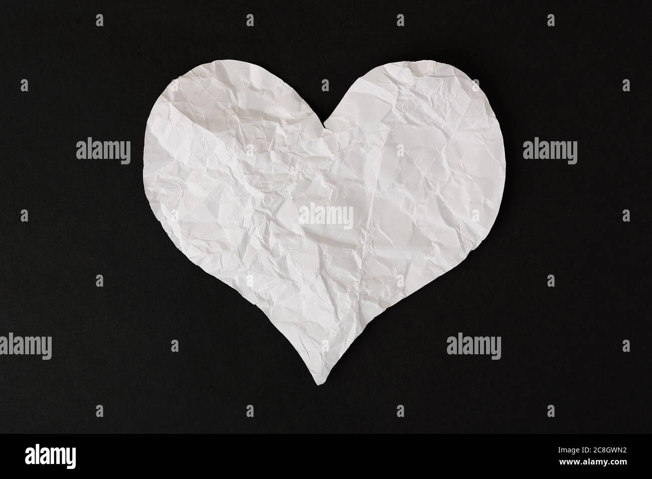 white crumpled paper love heart on black Stock Photo - Alamy