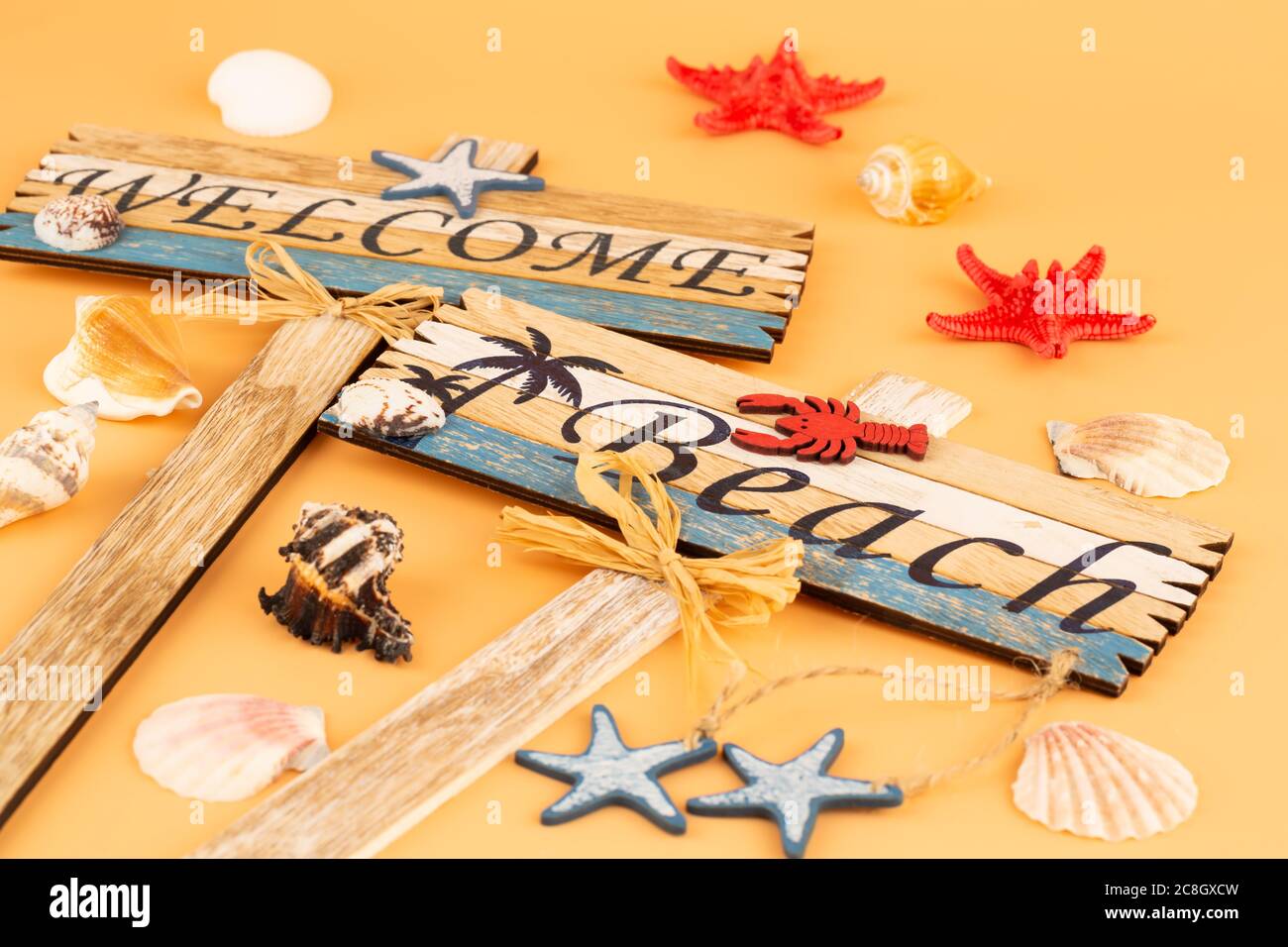 Wooden signs welcome beach, starfish and shells on yellow background ...
