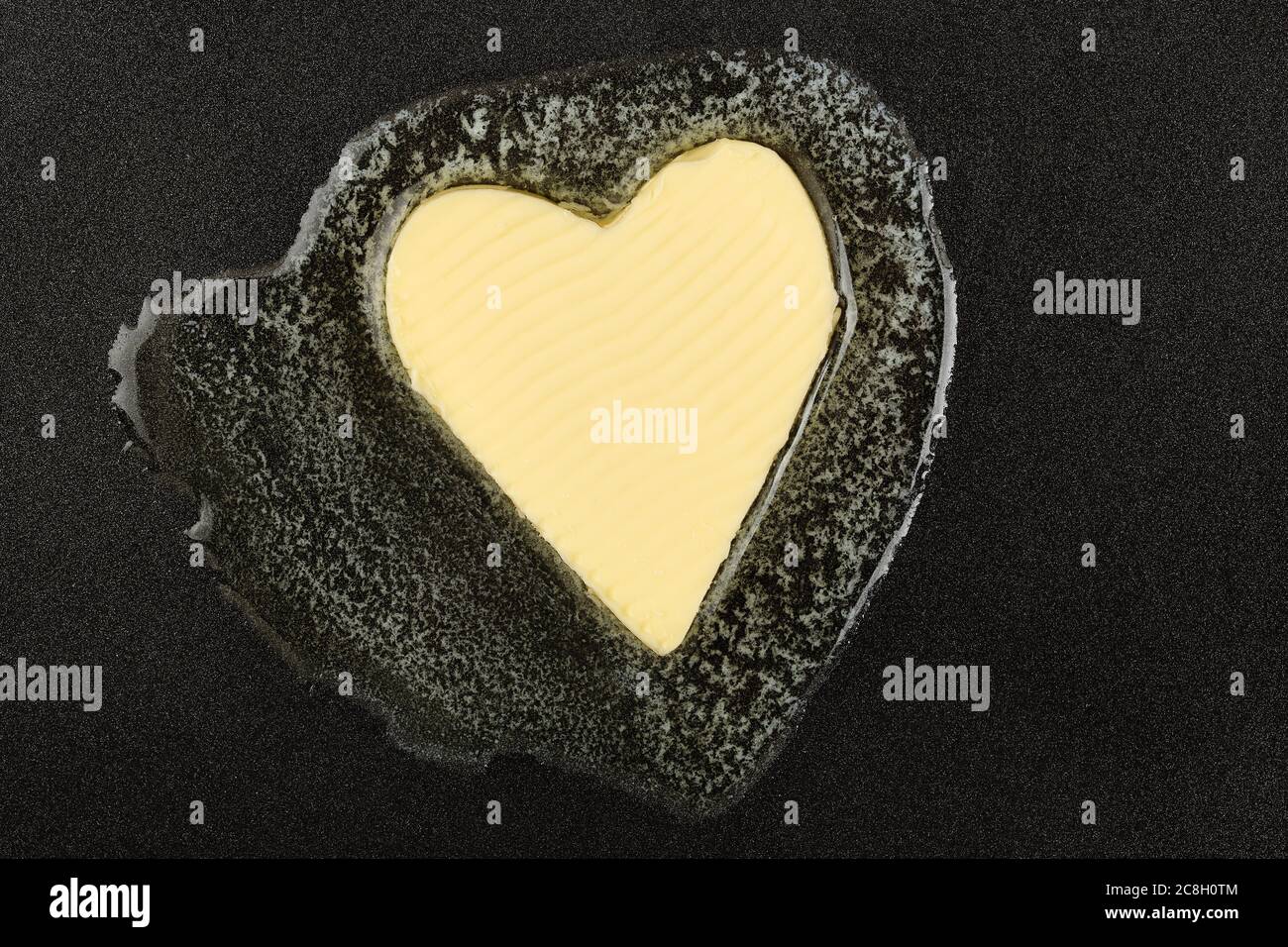 heart-shaped piece of butter melting on black pan Stock Photo - Alamy