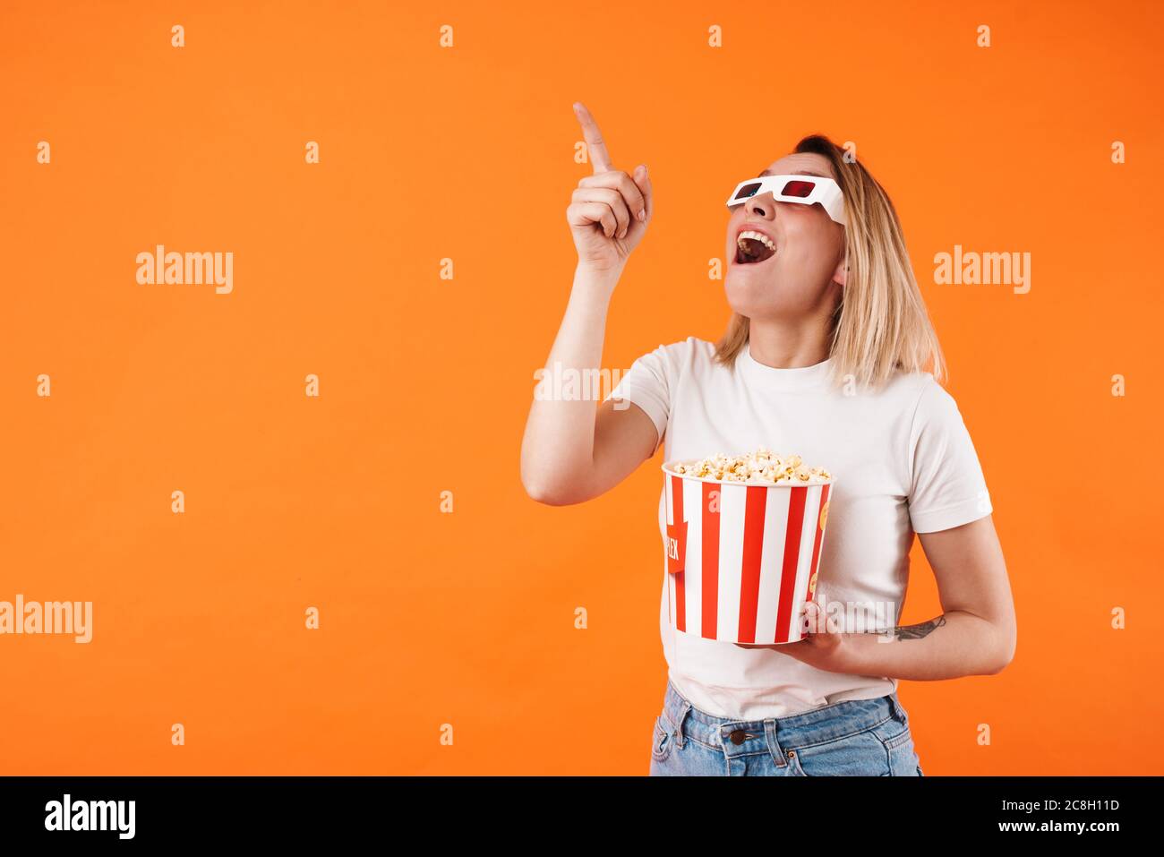 Image of excited woman in 3d glasses pointing finger upward while ...