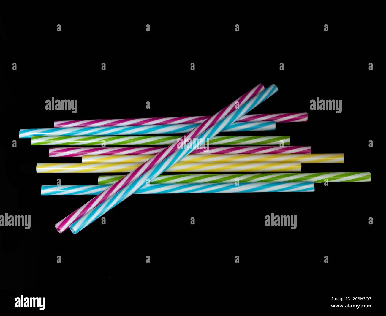 Piles of colorful striped plastic drinking straw, black underground ...