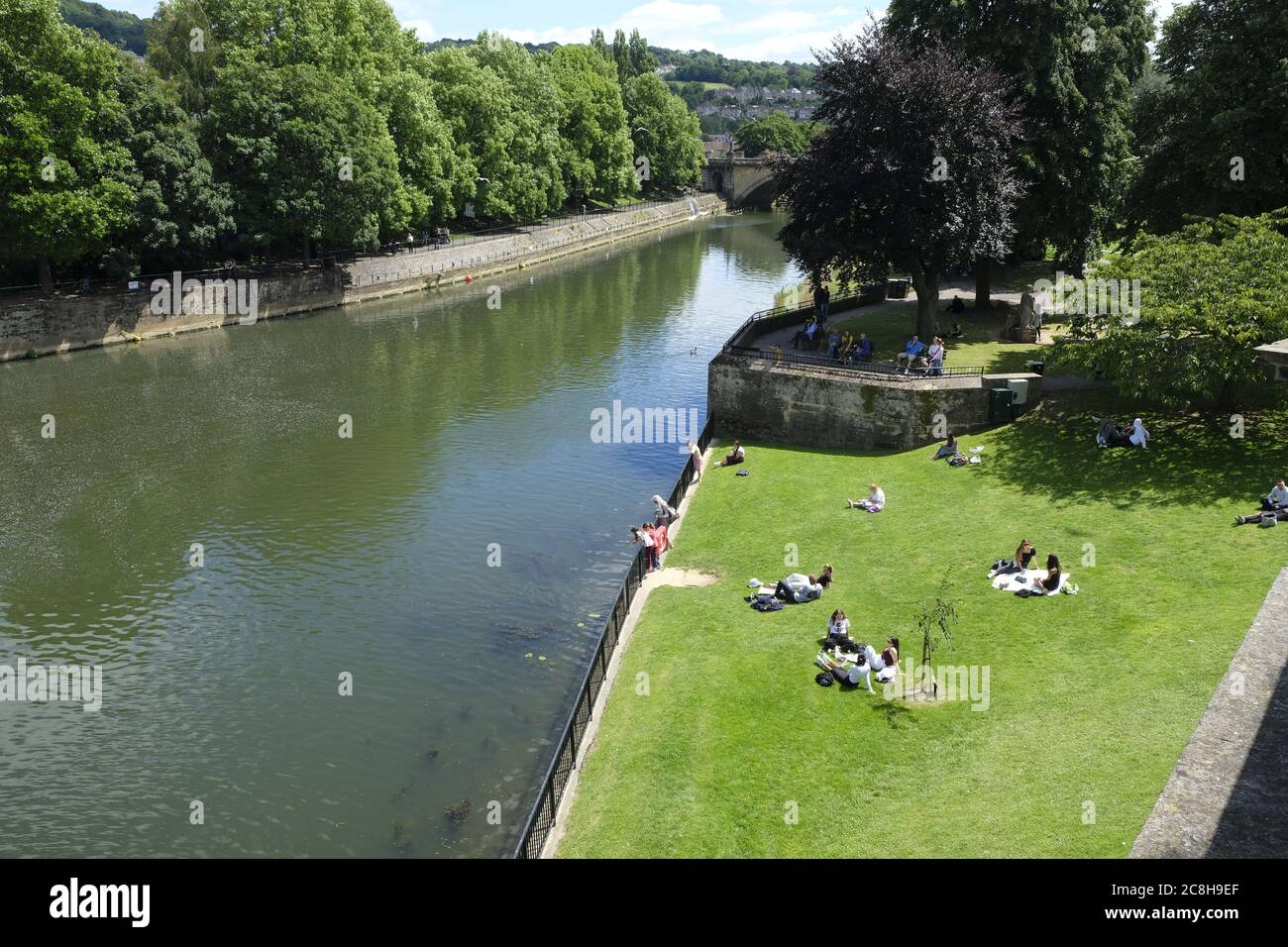 Tourists and locals sunbathing at the Bath Parade Gardens in Bath ...