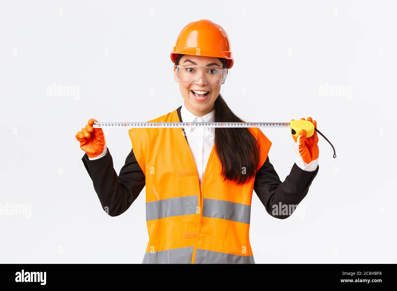 Excited and upbeat asian female construction engineer measuring layout ...