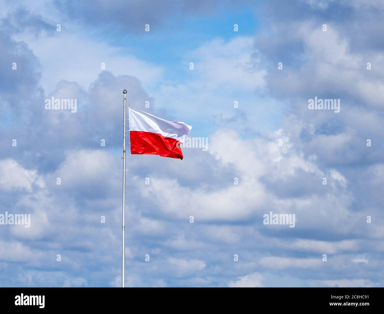 on a flagpole the red and white flag of Poland is waving Stock Photo ...