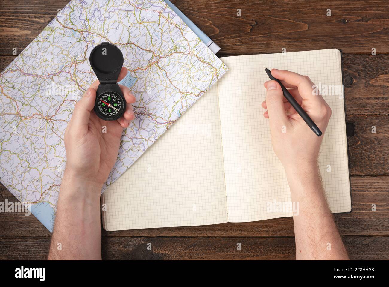Travel planning concept. Hand writing in blank notepad with compass and ...