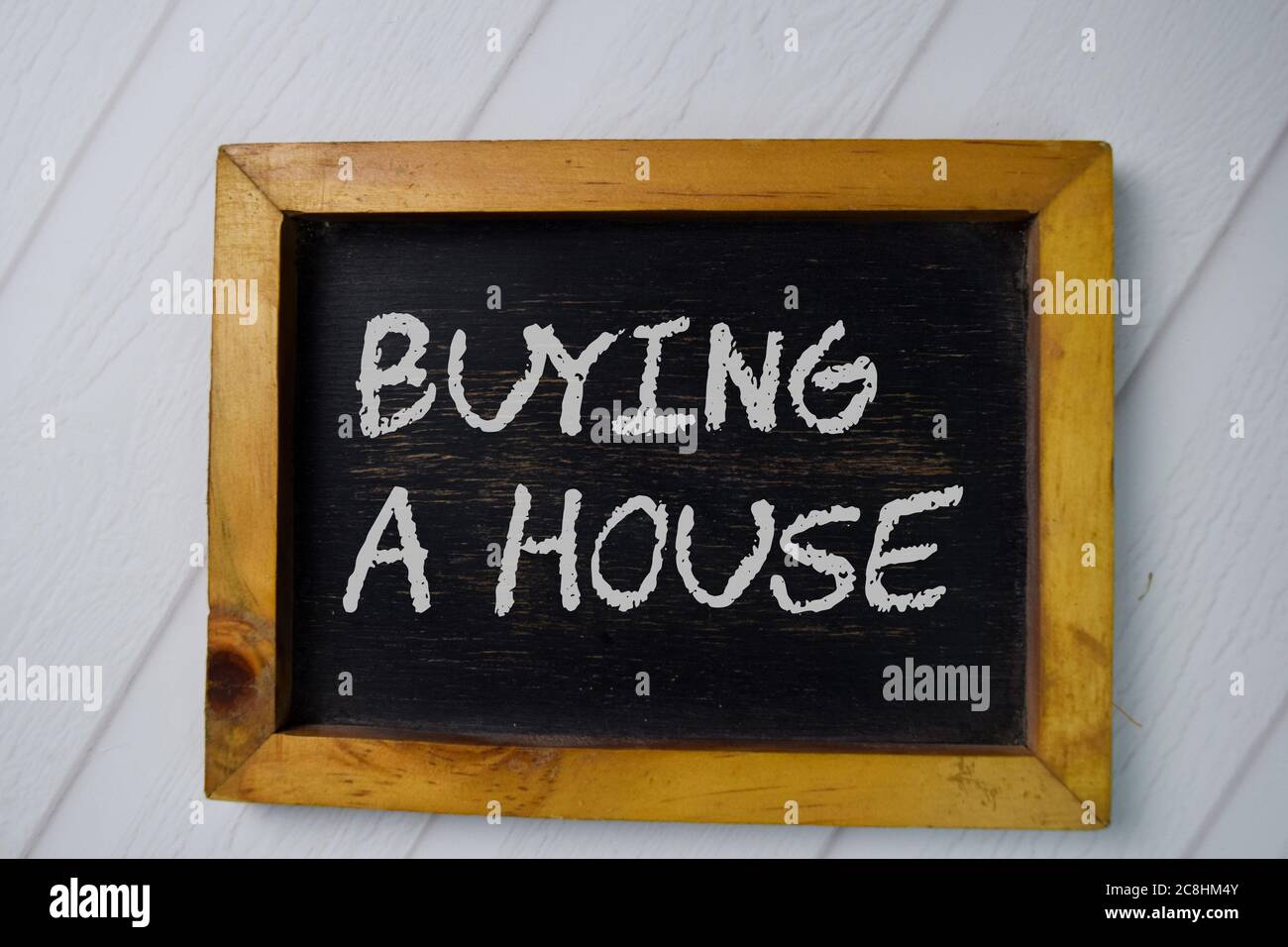 Buying a House text write on chalkboard isolated on office desk Stock ...