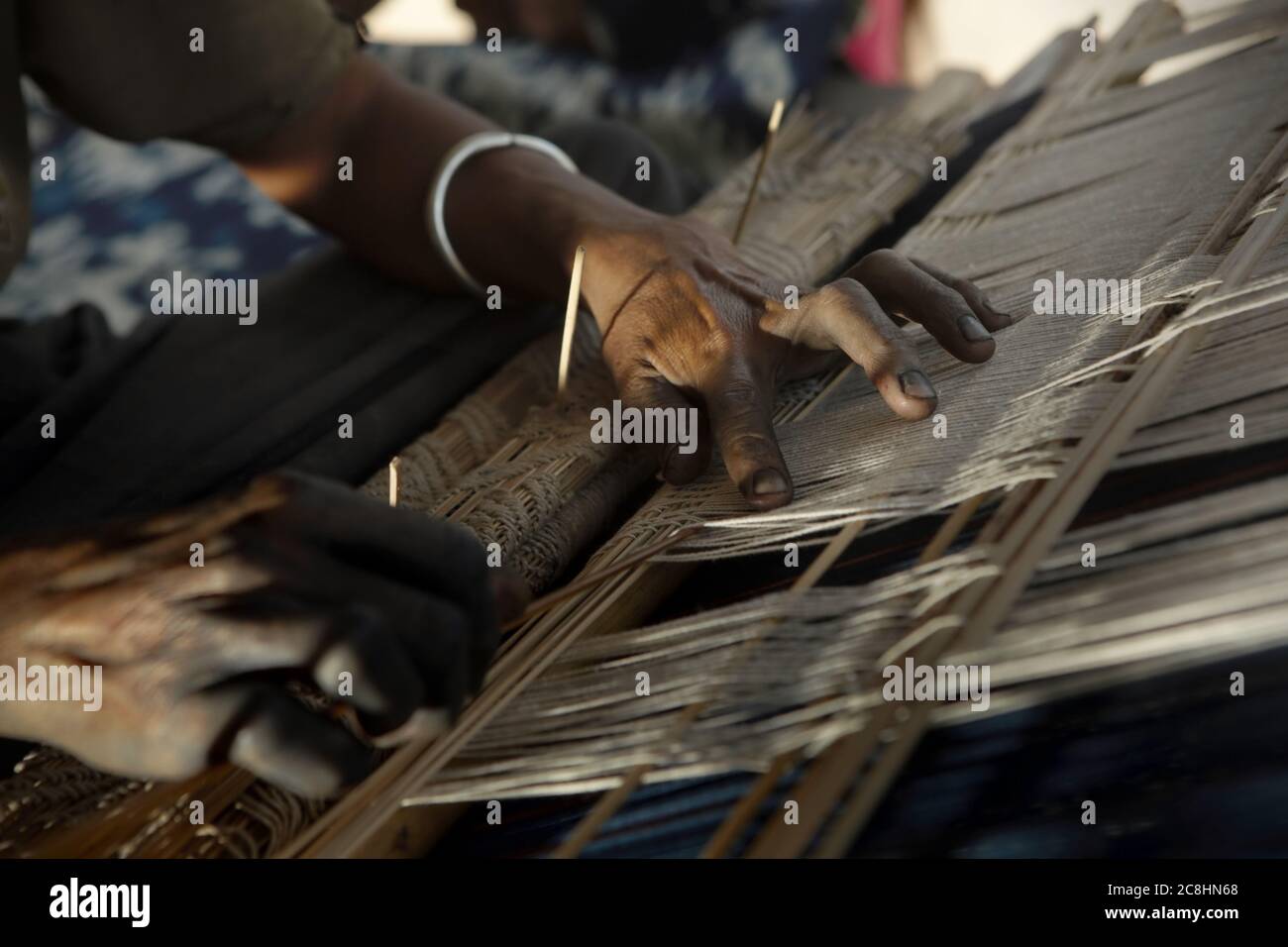 A woman weaving to create a Sumba textile in Umbara, Pau, Sumba Island ...