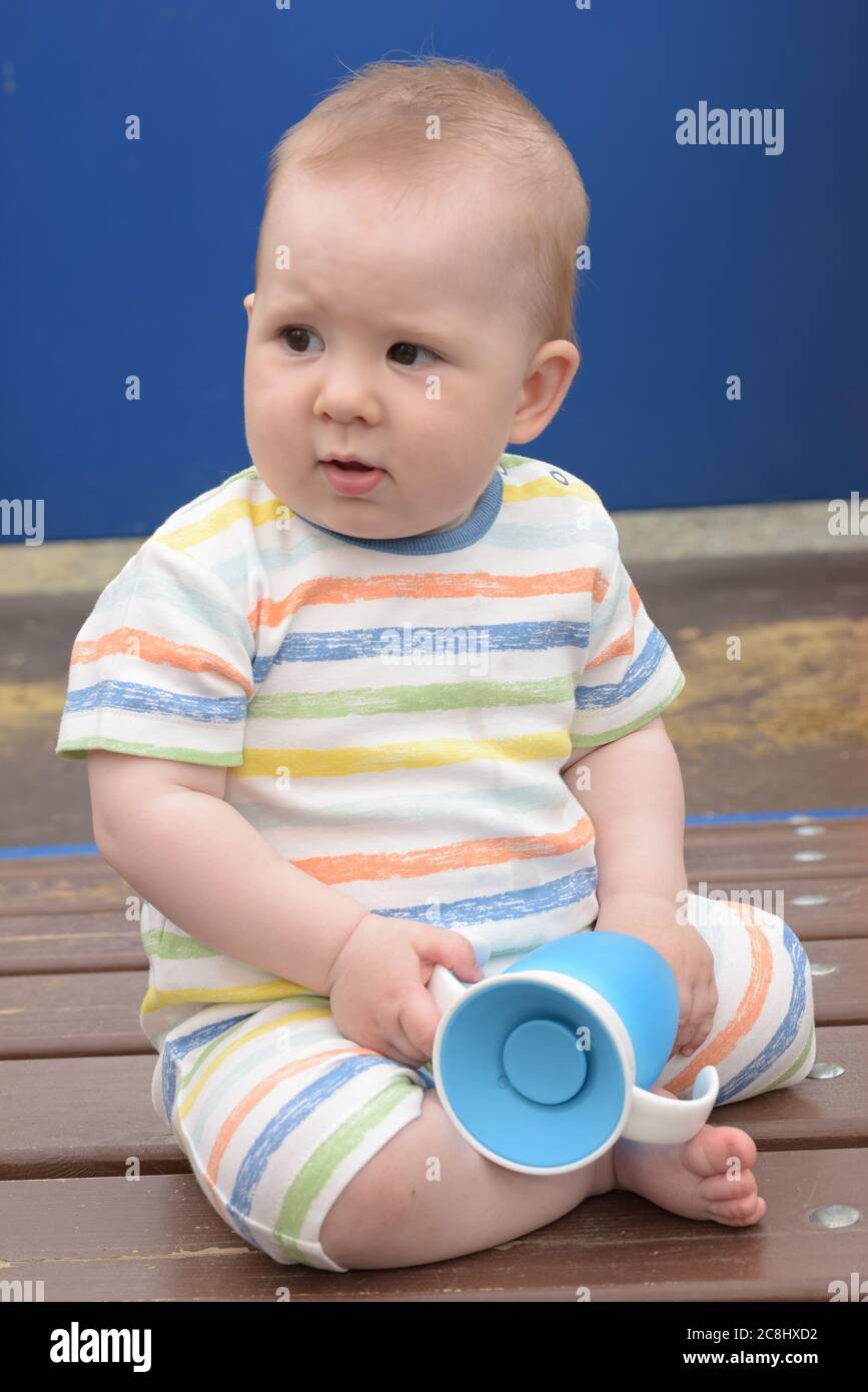 Little baby with water mug Stock Photo - Alamy