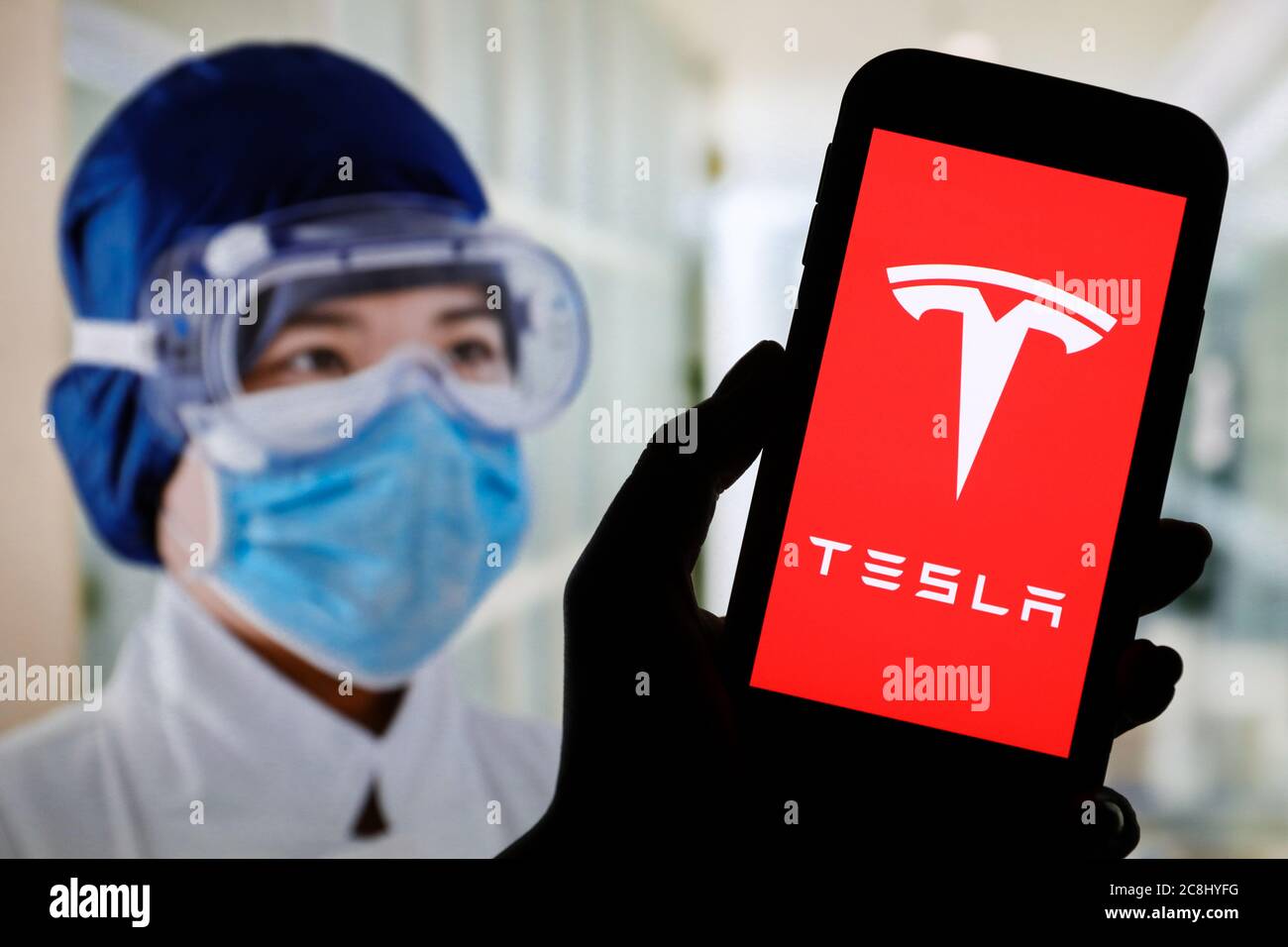 In this photo illustration a Tesla logo seen displayed on a smartphone ...