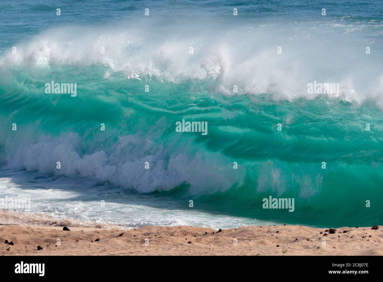 View of translucent wave breaking on beach, Georgetown, Ascension ...