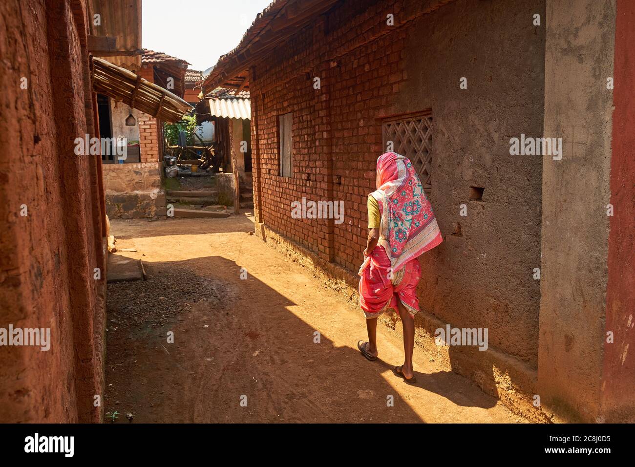 A village woman in typical Maharashtra style saree walks in a lane of a ...