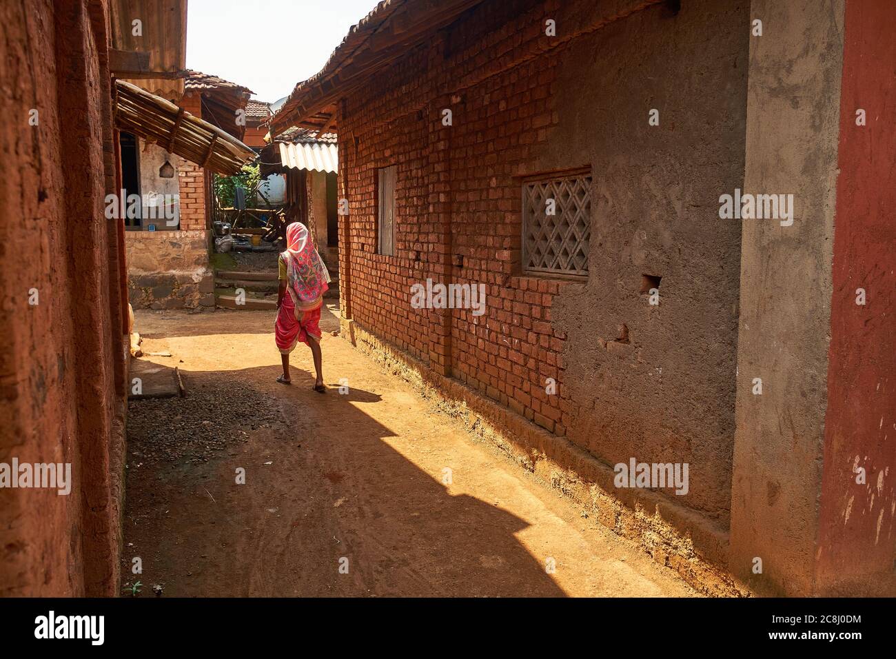 A village woman in typical Maharashtra style saree walks in a lane of a ...