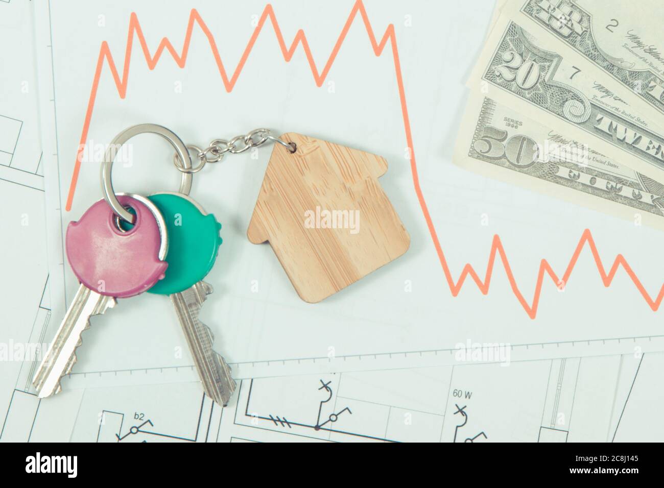 Keys of home, currencies dollars and downward graphs on electrical ...
