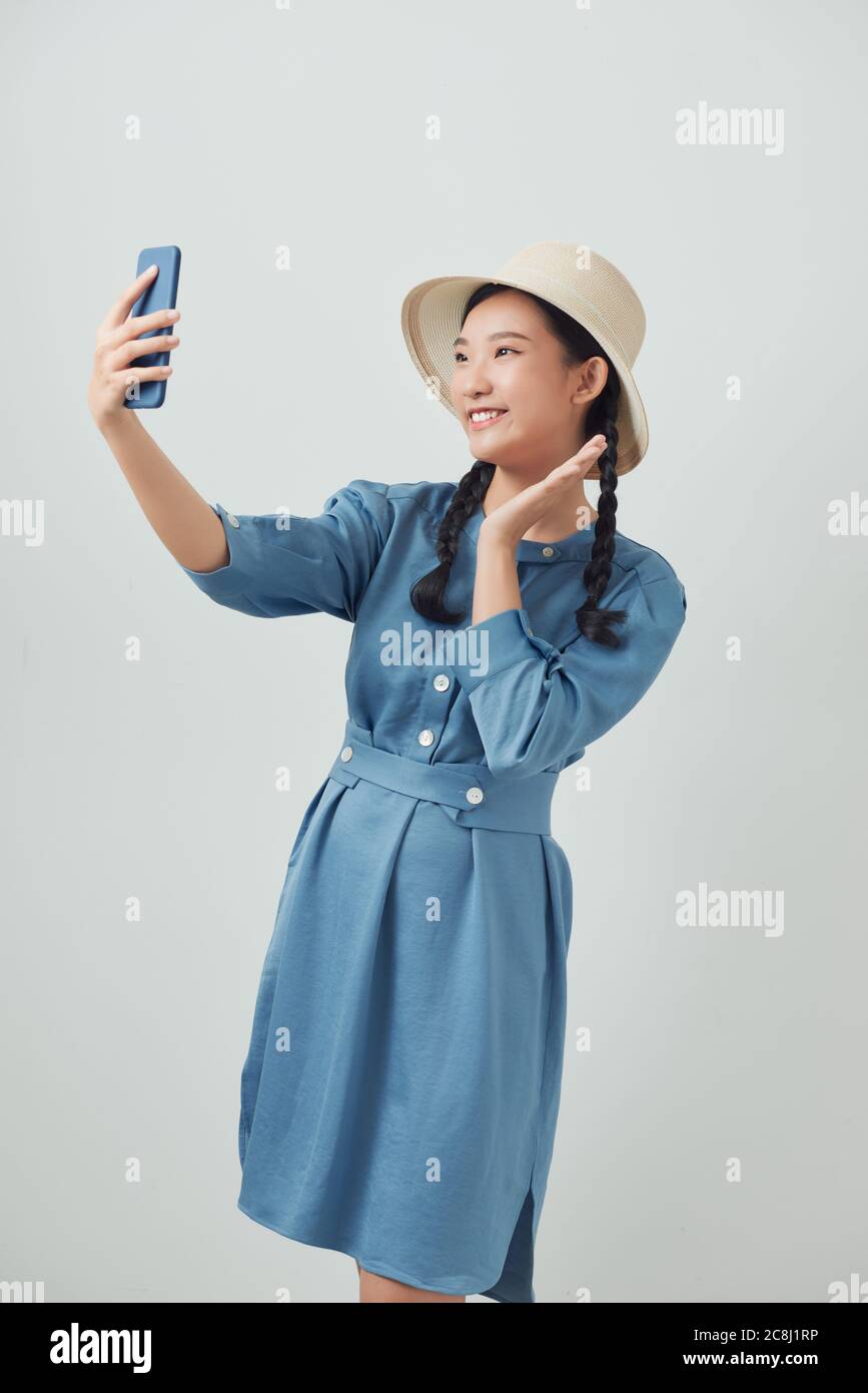 Emotional young woman taking selfie on white background Stock Photo - Alamy