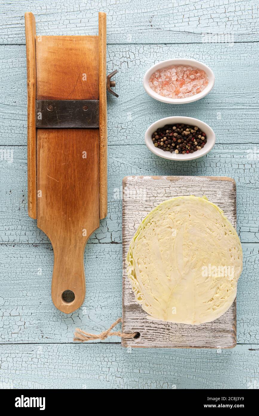 Old wooden cabbage grater, piece of cabbage, assorted pepper and ...