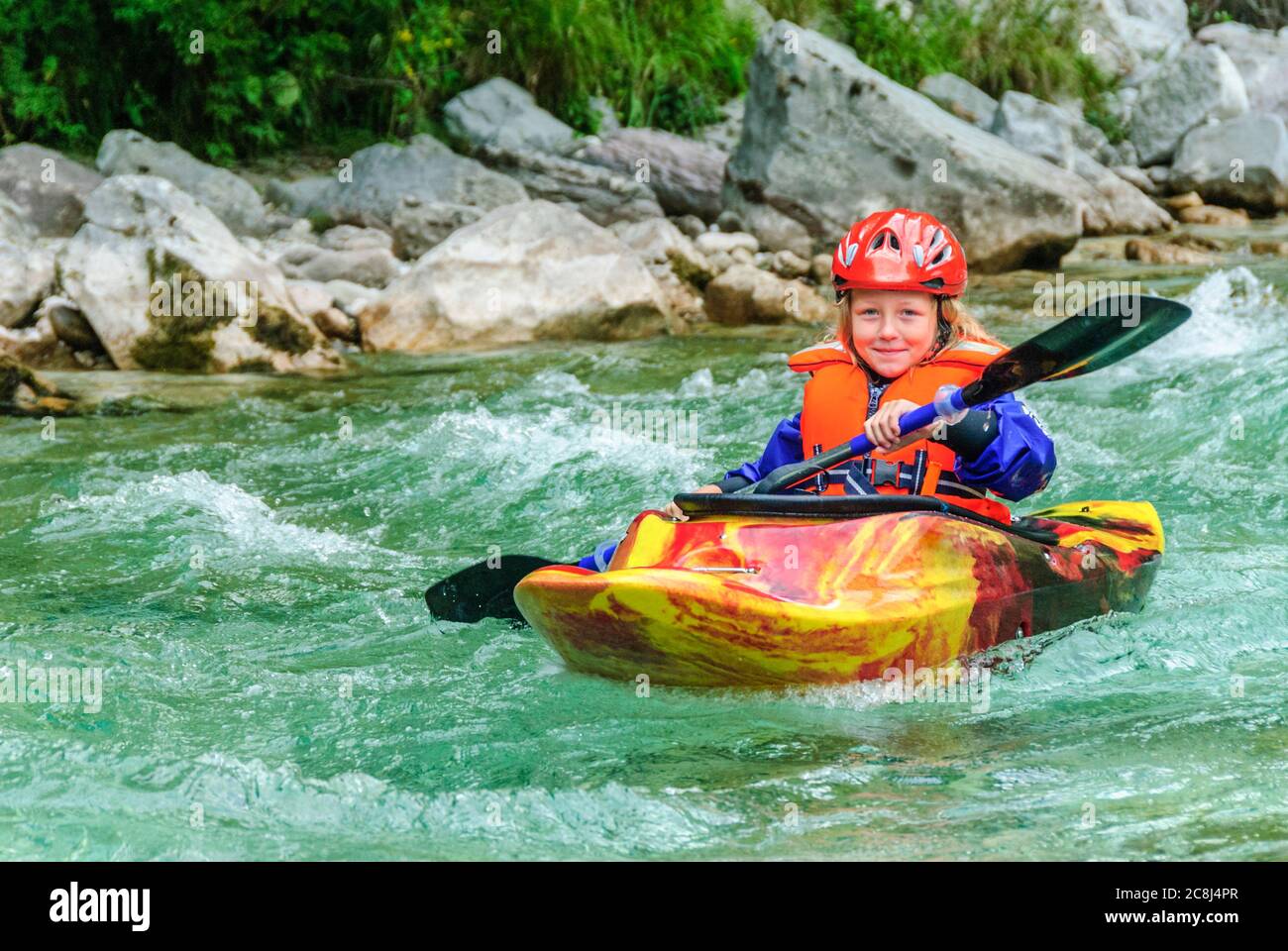 Courageous little girl paddling in kayak on alpine river Stock Photo ...