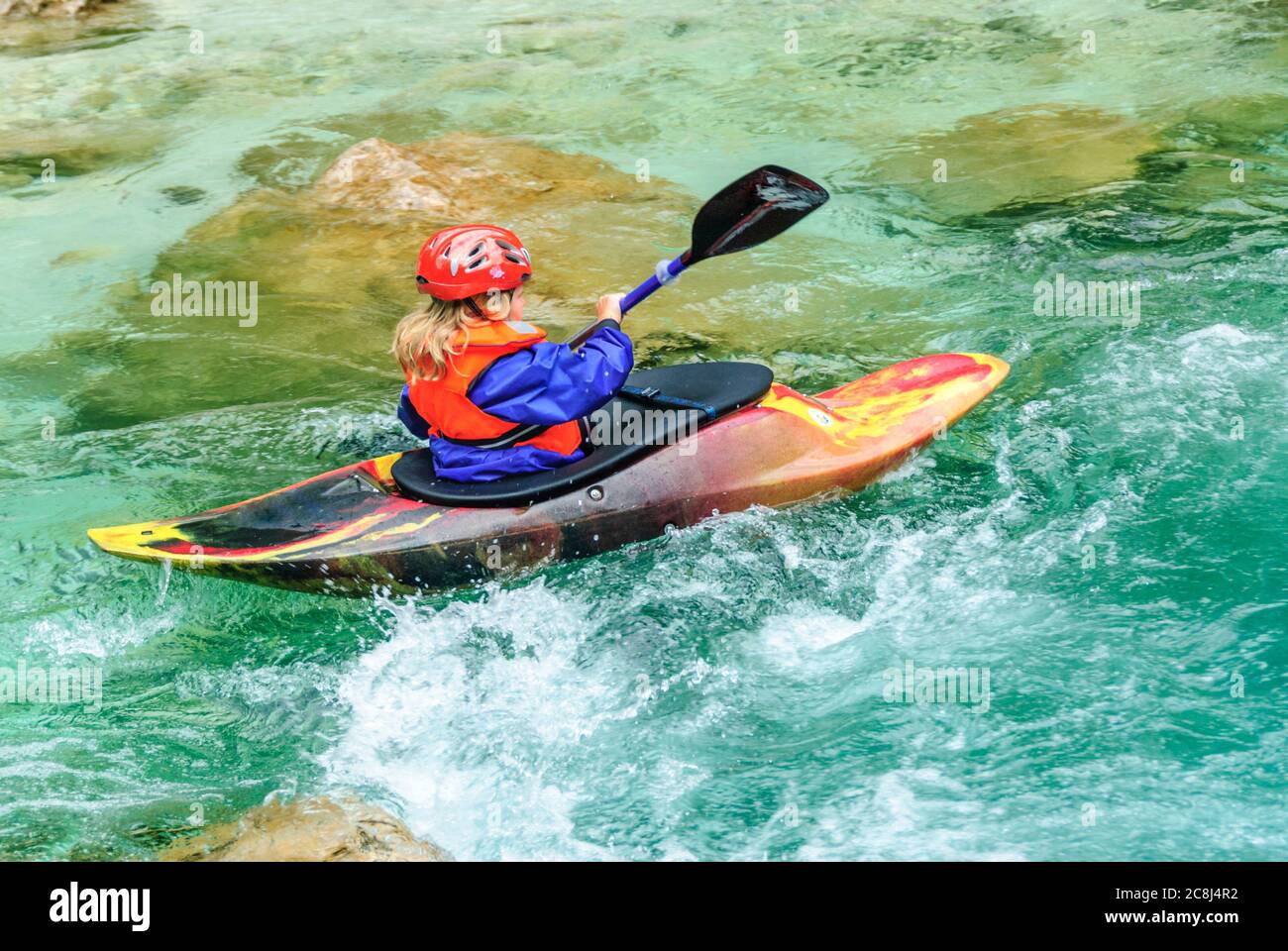 Courageous little girl paddling in kayak on alpine river Stock Photo ...